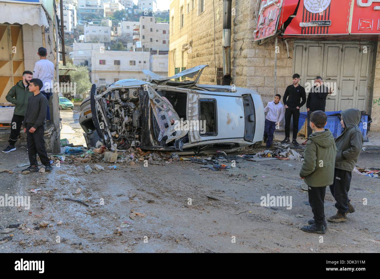 Palestinians gather around a flipped car as the military closes Hebron ...