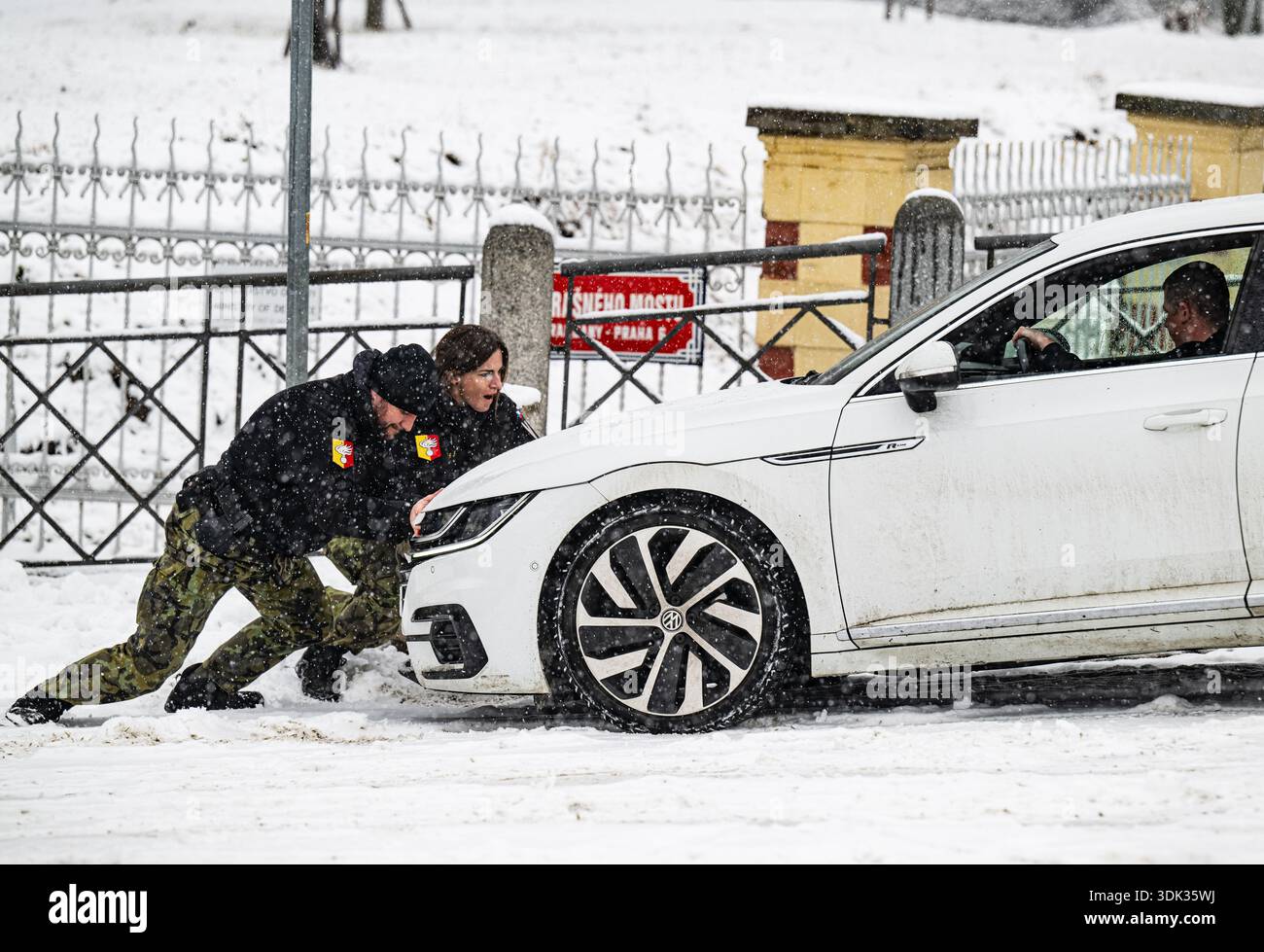 A man and a woman help to push out a stranded car on 29 January 2026 ...