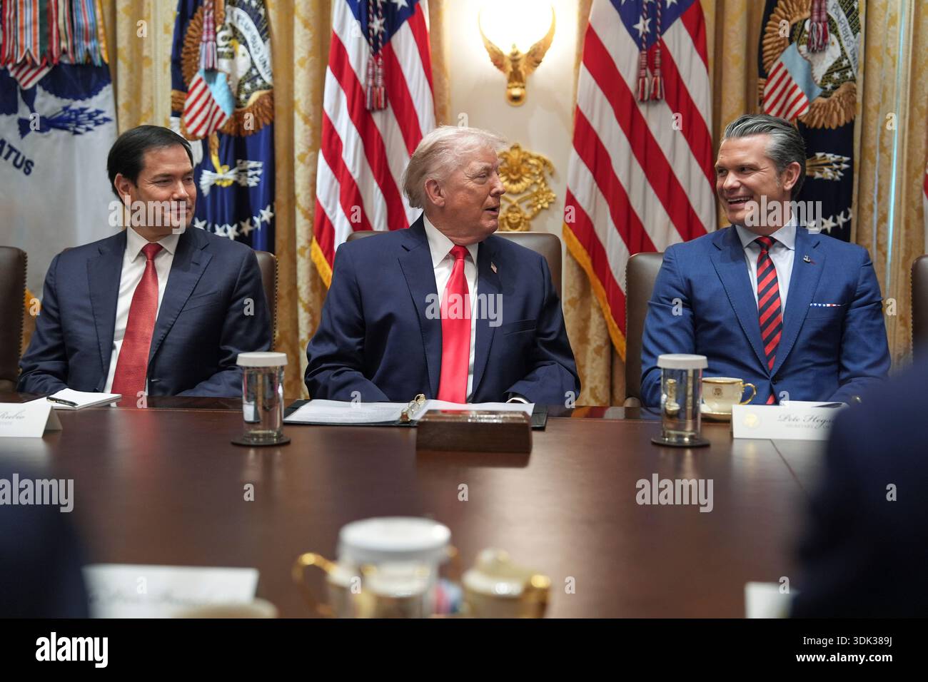 Defense Secretary Pete Hegseth smiles as President Donald Trump speaks ...
