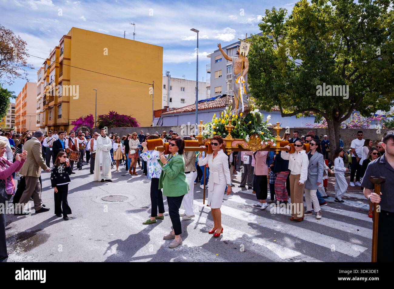 A group of women dressed in formal attire carry the religious float ...