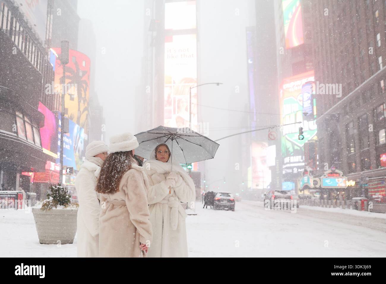 FILE - People wait to cross the street in Times Square during a winter ...