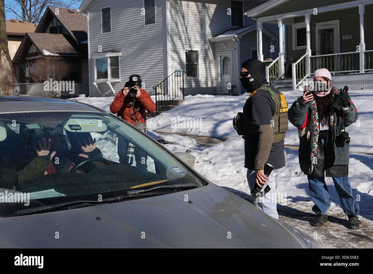 People film as a federal agent approaches a vehicle on Thursday, Jan ...