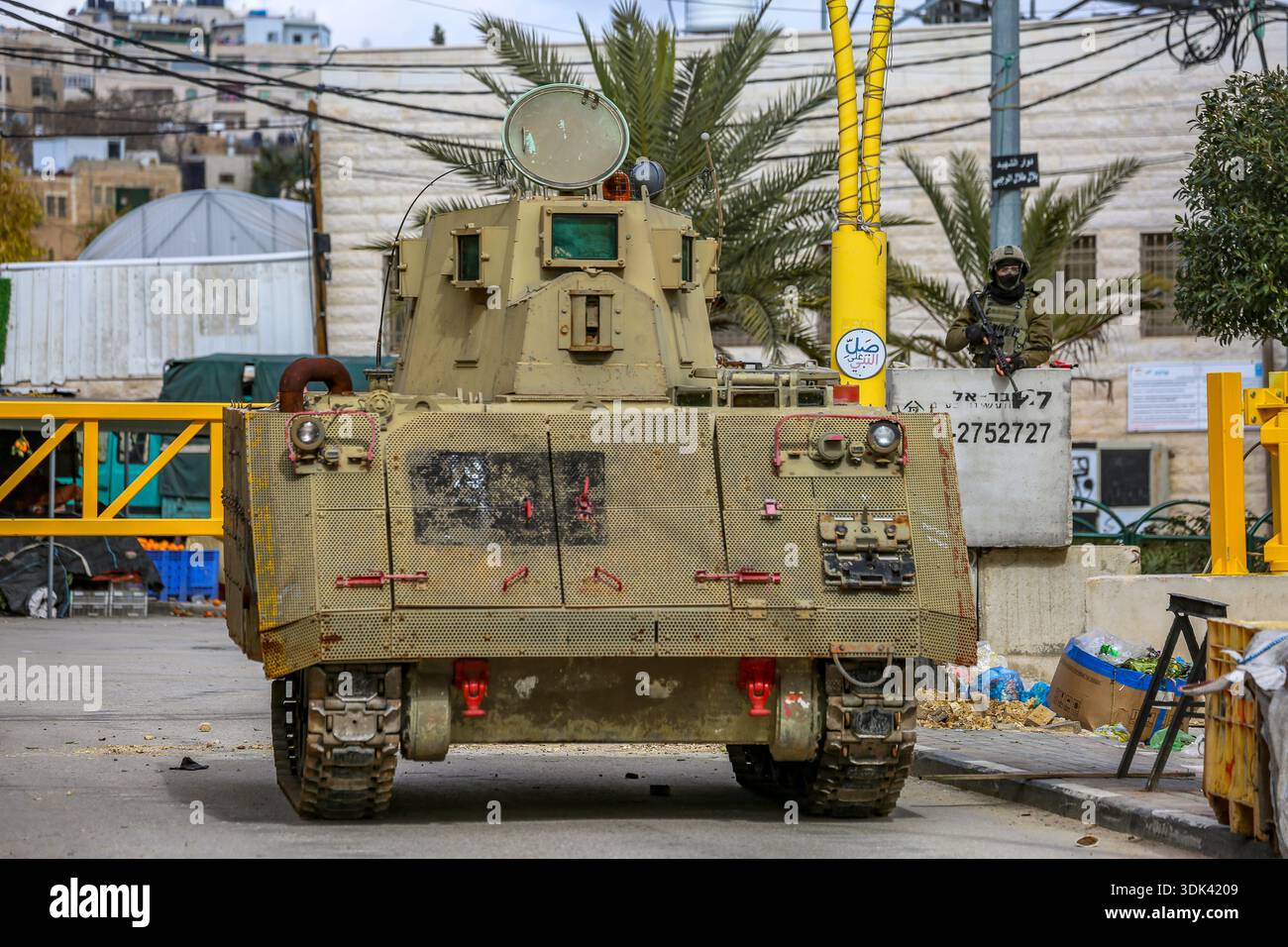 An Israeli forces armored vehicle stands guard next to a barrier during ...