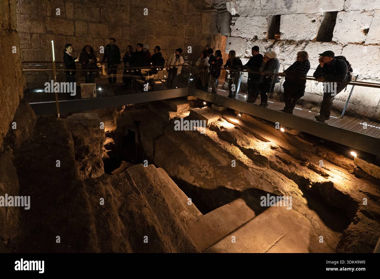 Visitors receive an explanation of the Rock cut Mikveh Jewish ritual ...