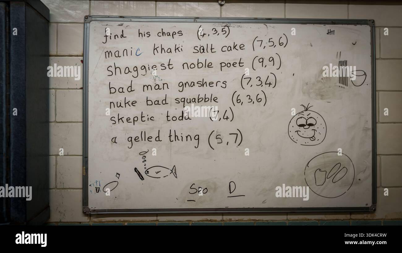 Whiteboard in tiled room with handwritten word puzzles, numbers, tally ...