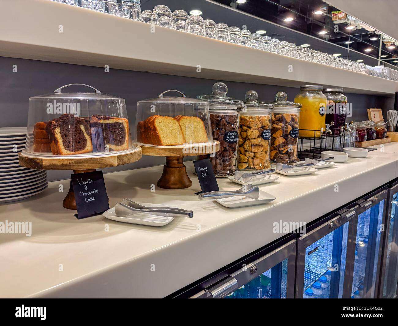 Airport lounge self-service counter with cakes, cookies, and juice ...
