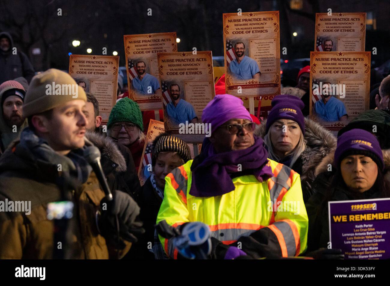 Nurses and their supporters hold signs during a vigil for Alex Pretti ...