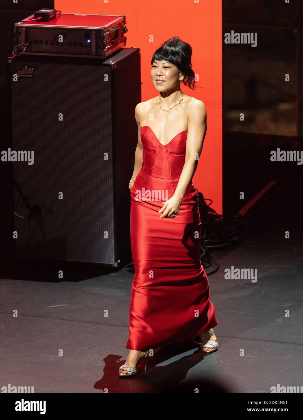 Ali Ahn wearing dress by Gustavo Cadile walks on stage during American ...