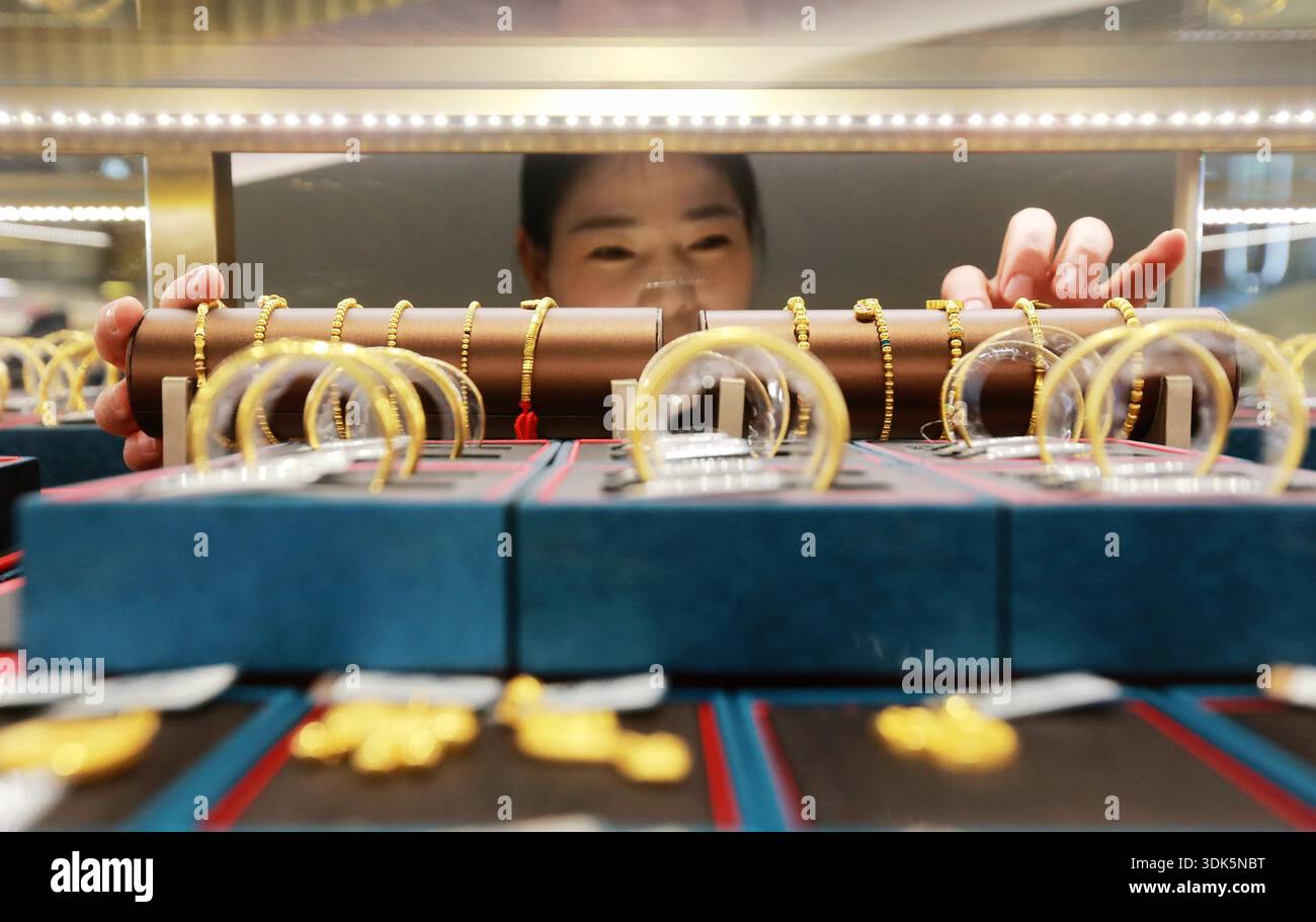 A staff member arranges gold jewelry at a gold store in Yangzhou City ...