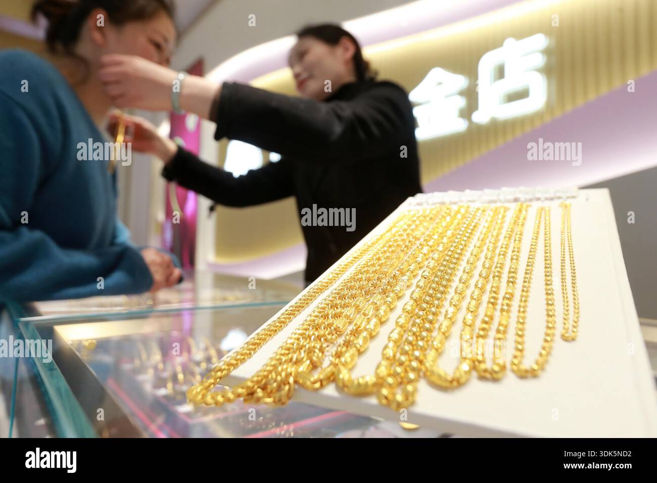 A staff member arranges gold jewelry at a gold store in Yangzhou City ...