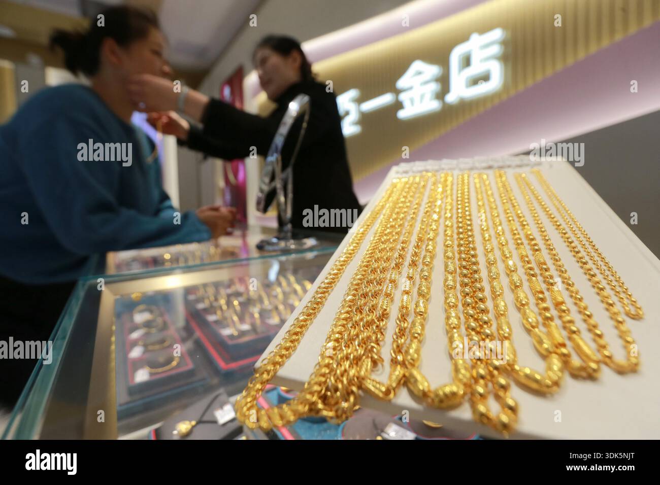 A staff member arranges gold jewelry at a gold store in Yangzhou City ...