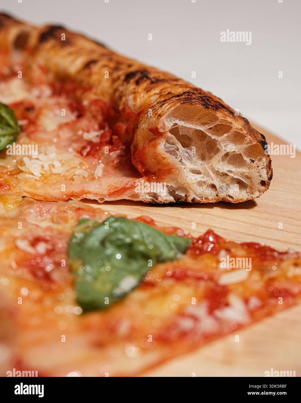 closeup airy pizza crust open crumb, blistered edge and char, large ...