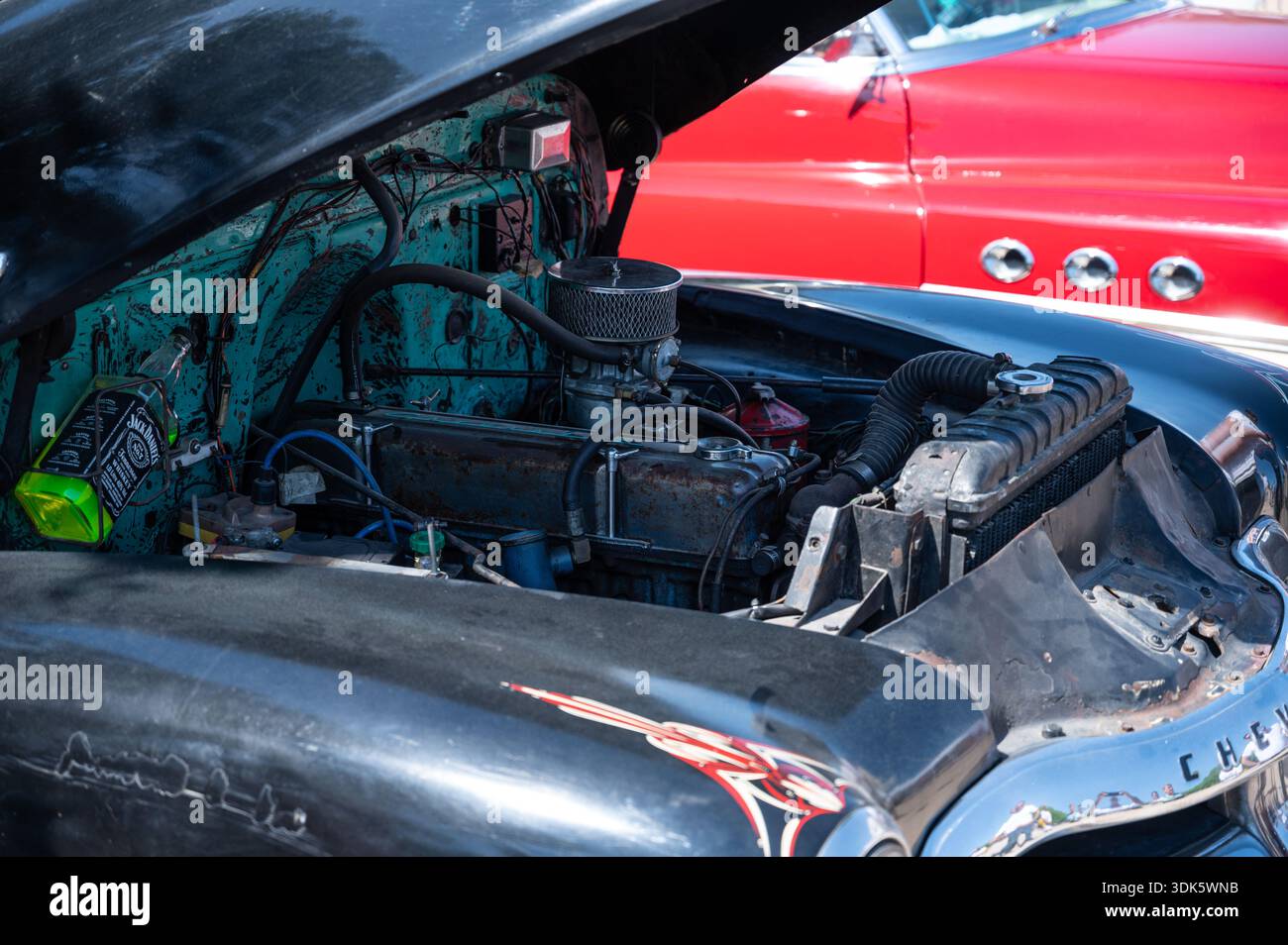 A close-up detail shot of the engine bay of a classic black 1954 ...