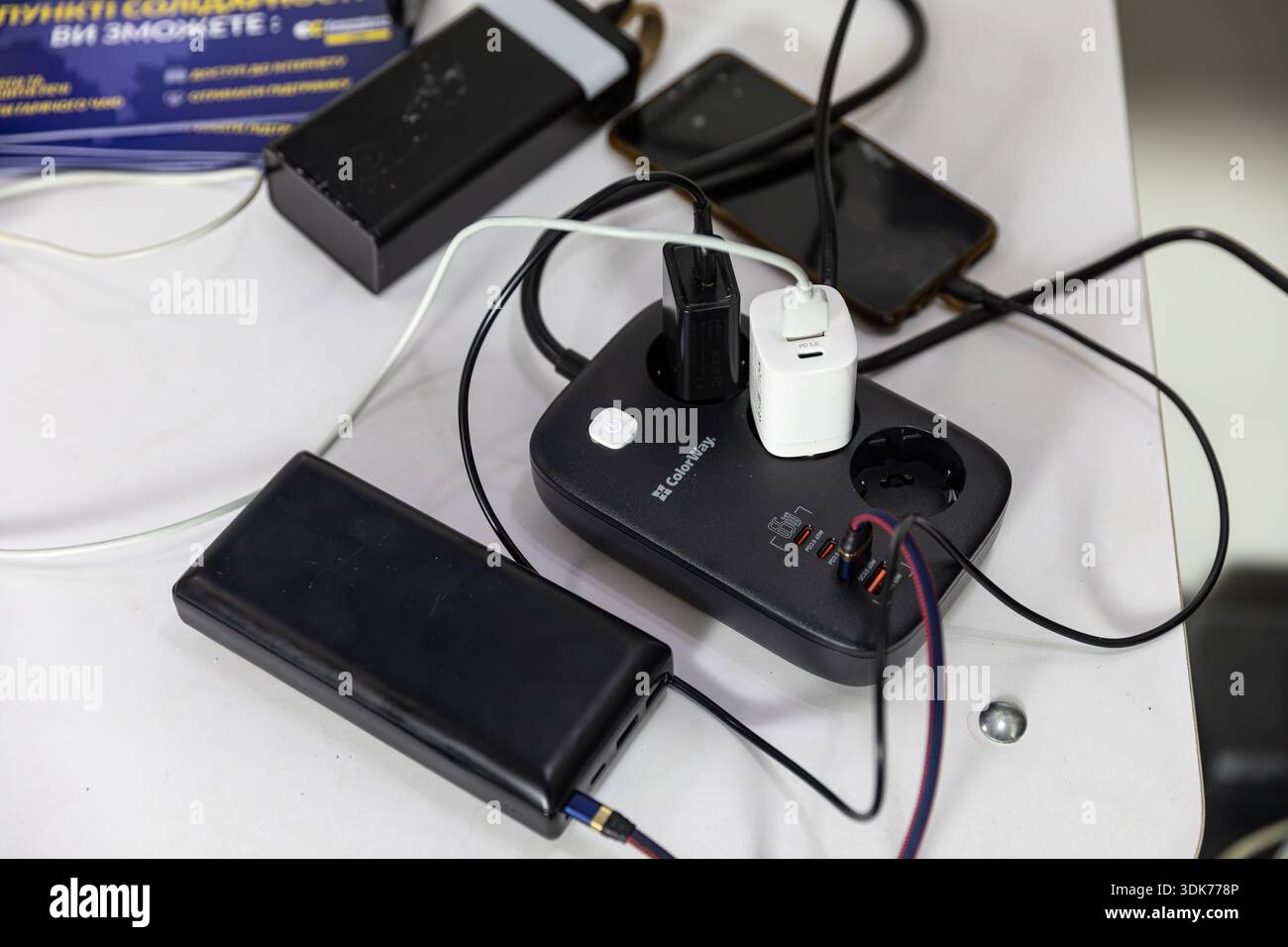 Electronic devices and chargers seen plugged into a power strip at a ...