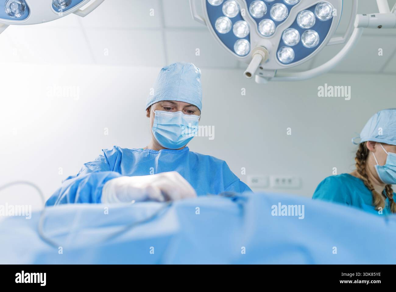 Female medical staff work together in a modern hospital operating room ...