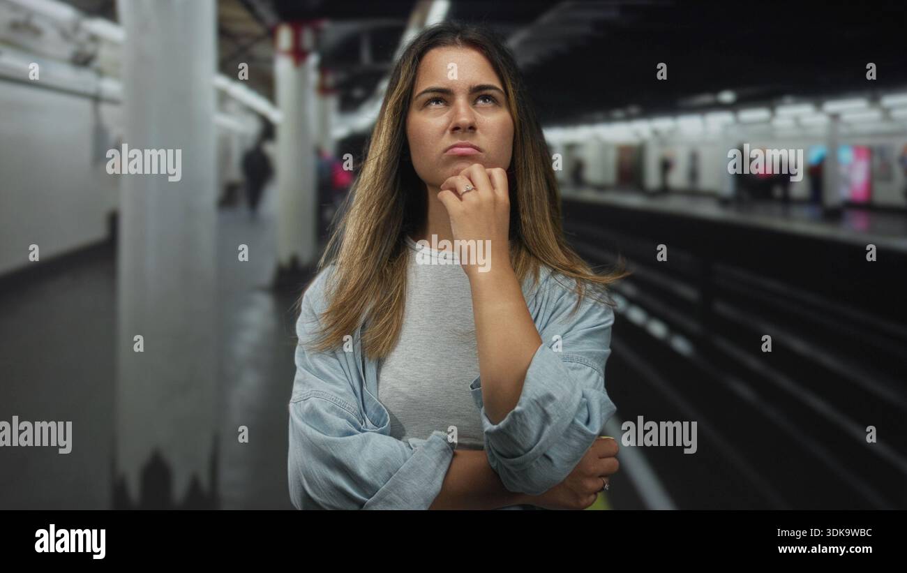 Teenage woman touching cheek and showing middle finger on a subway ...