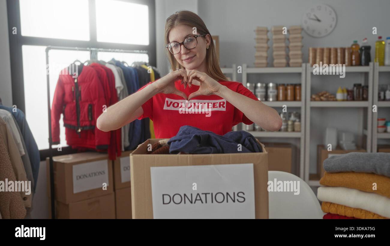 Woman forms heart shape gesture with hands over donation box in ...