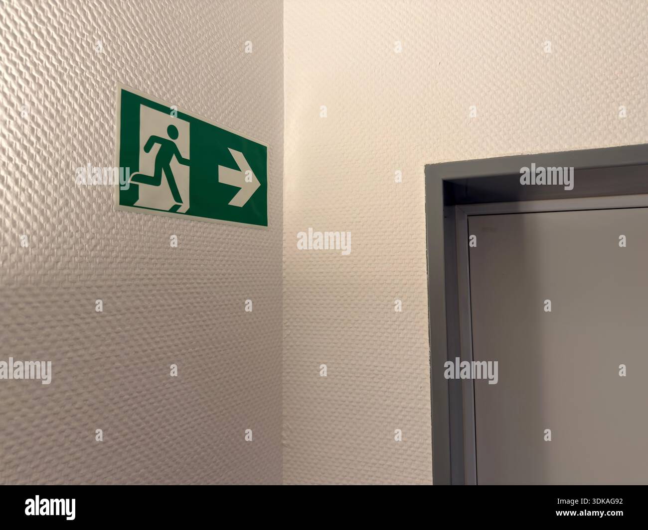 Emergency exit sign mounted above an interior doorway highlighting ...