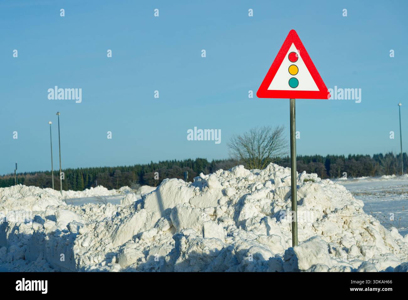 Traffic warning sign standing in front of massive snowbanks after ...