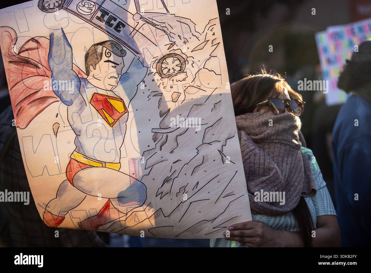 A protester holds a hand-drawn sign depicting Superman confronting ICE ...