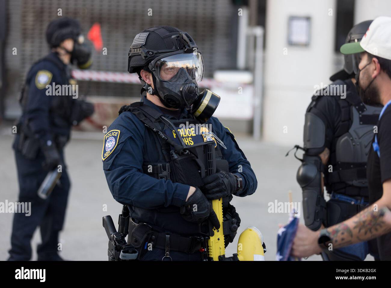 A Department of Homeland Security police officer wearing a gas mask and ...