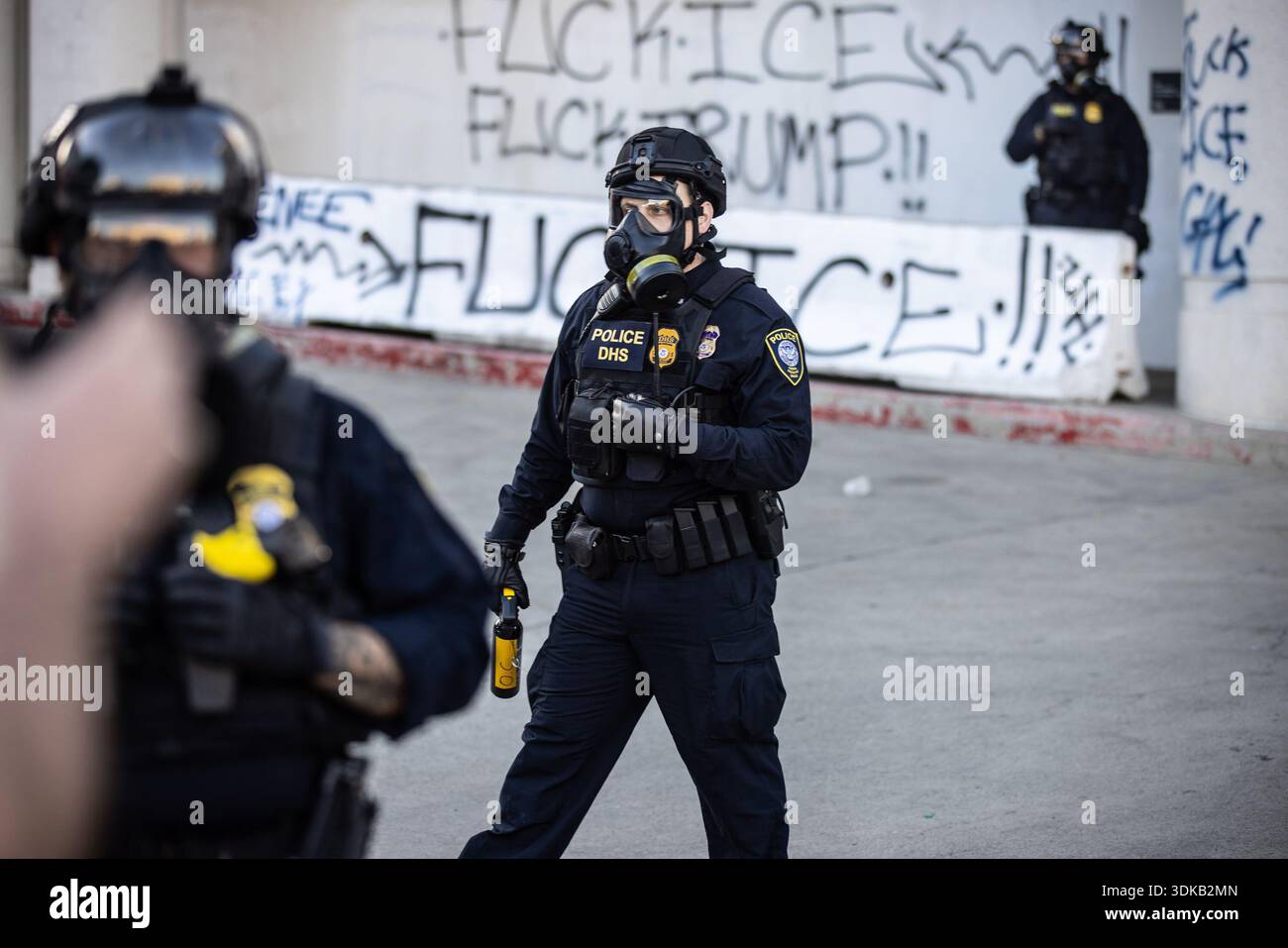 A Department of Homeland Security police officer in riot gear stands in ...