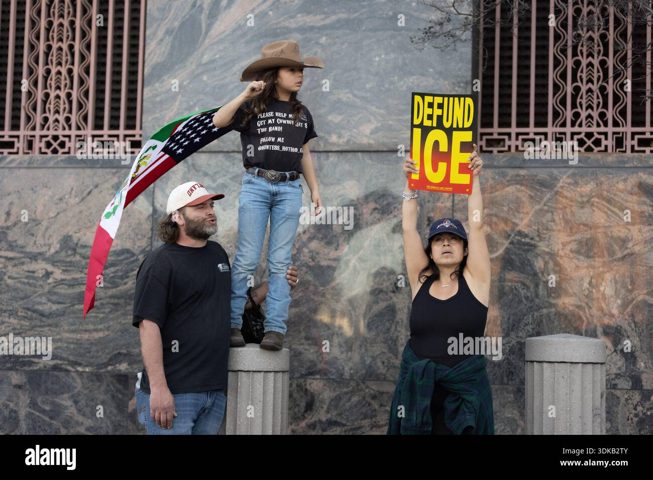 A child stands elevated during an ICE Out protest in Los Angeles ...