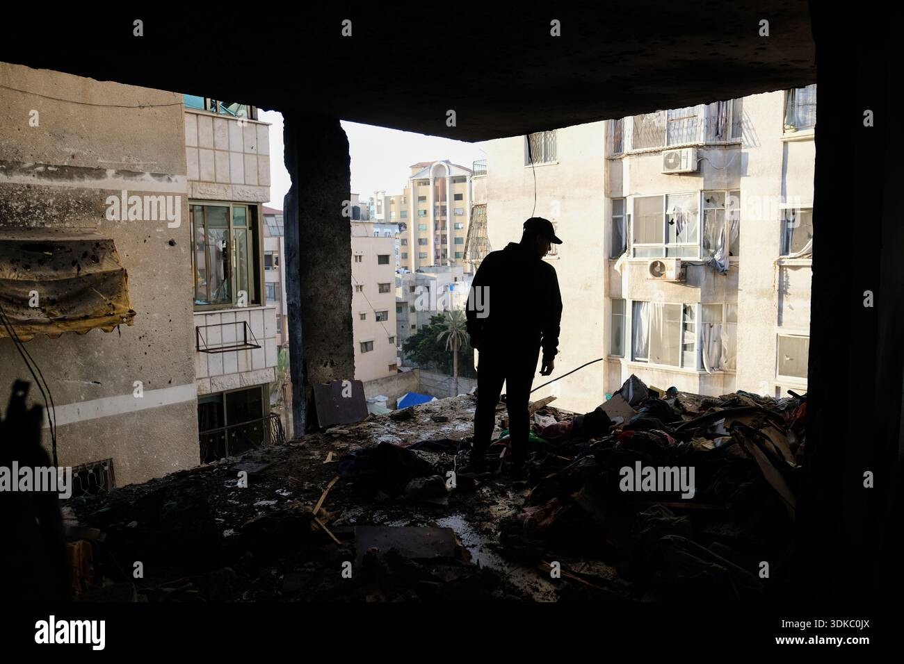 A Palestinian man surveys the damage to an apartment building after an ...