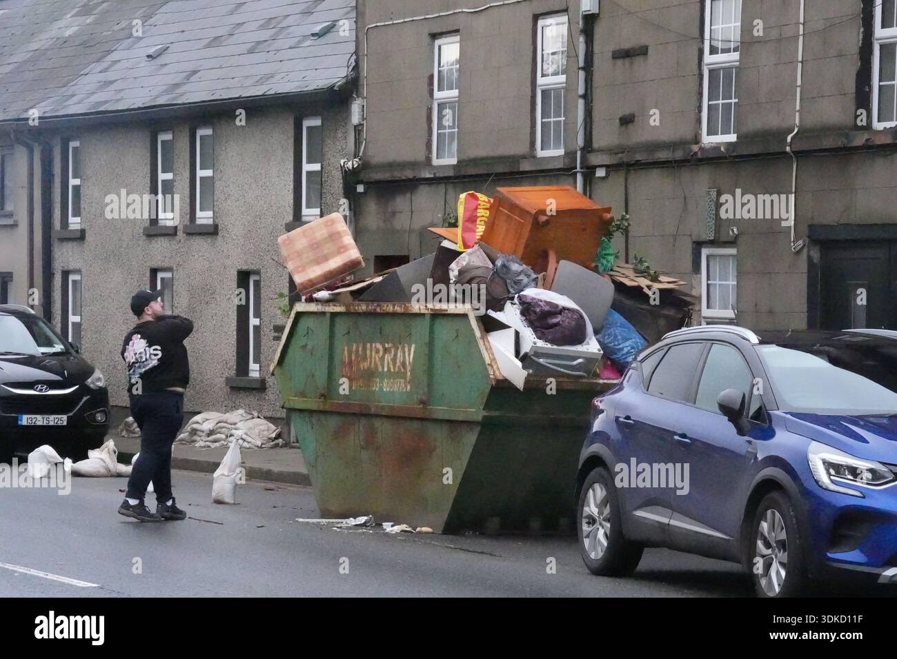 A resident puts items in a skip in Enniscorthy co Wexford which ...