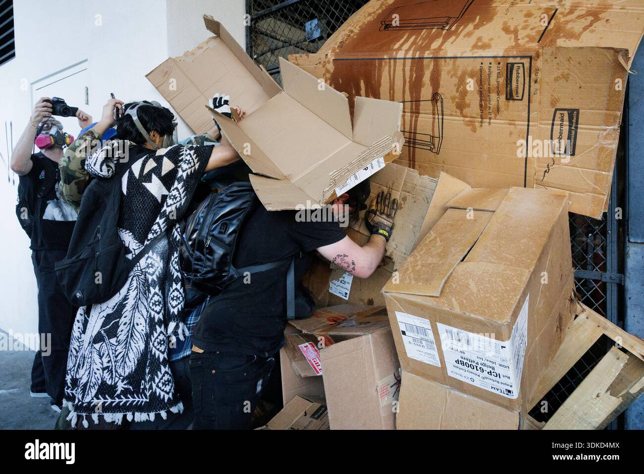 Protesters use cardboard and other trash to protect themselves from ...