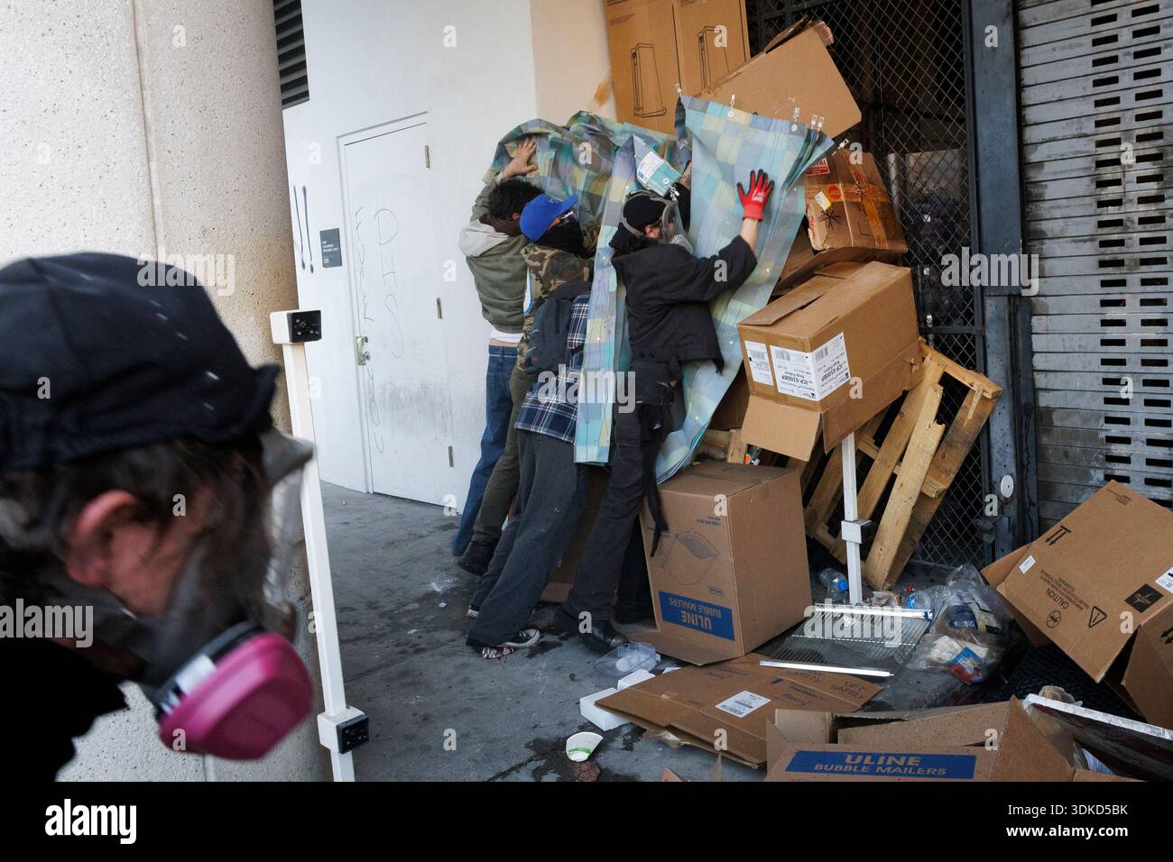 Protesters use cardboard and other trash to protect themselves from ...
