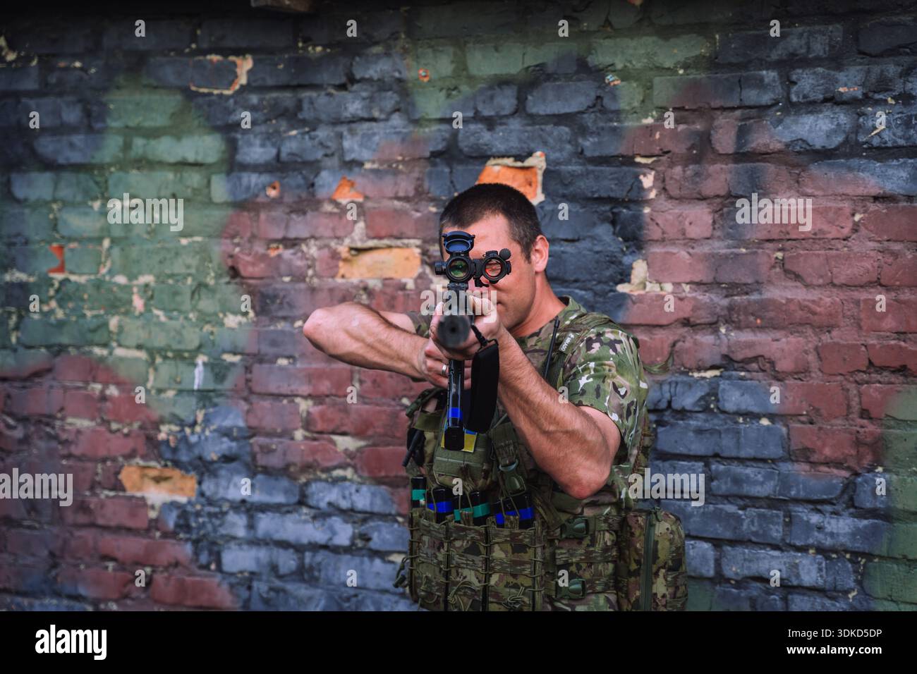 Ukrainian soldier in camouflage uniform aiming a rifle during active ...