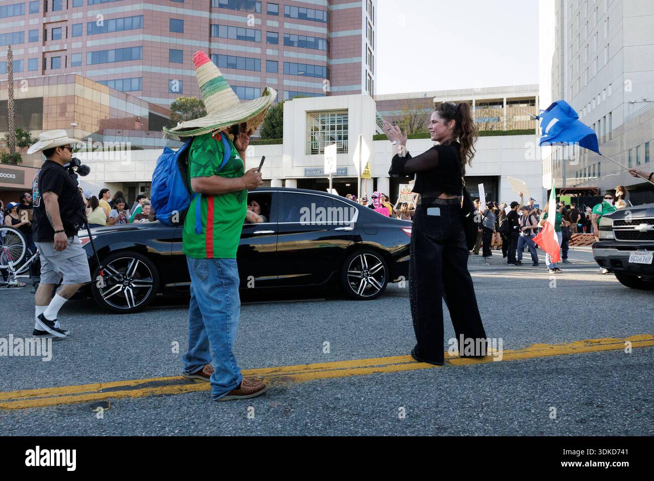 Protesters wave at passing cars and encourage them to honk their horns ...