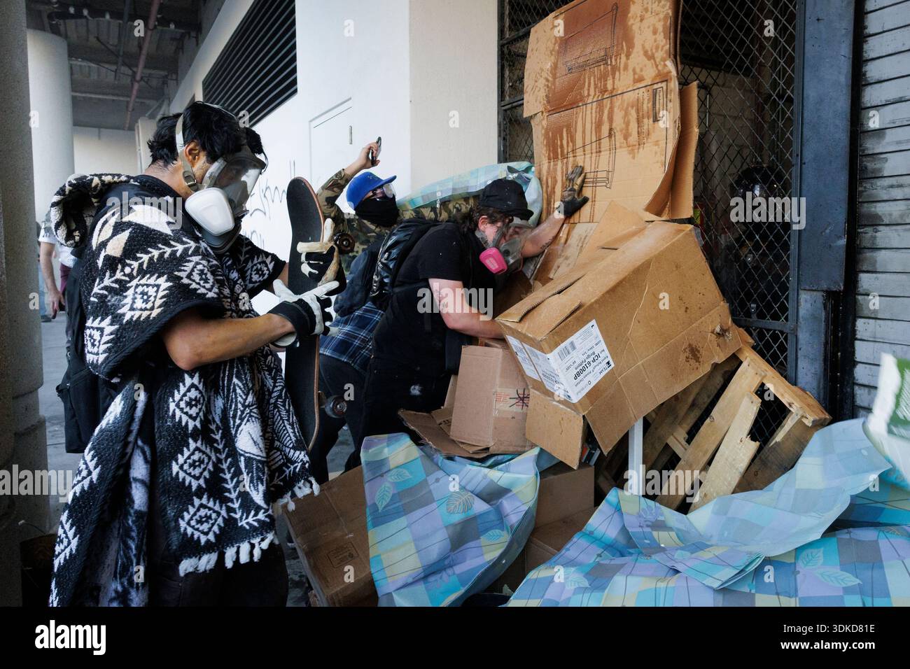 Protesters use cardboard and other trash to protect themselves from ...