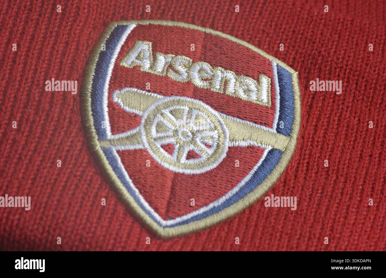 Arsenal football club crest in close up embroidered on a red shirt ...