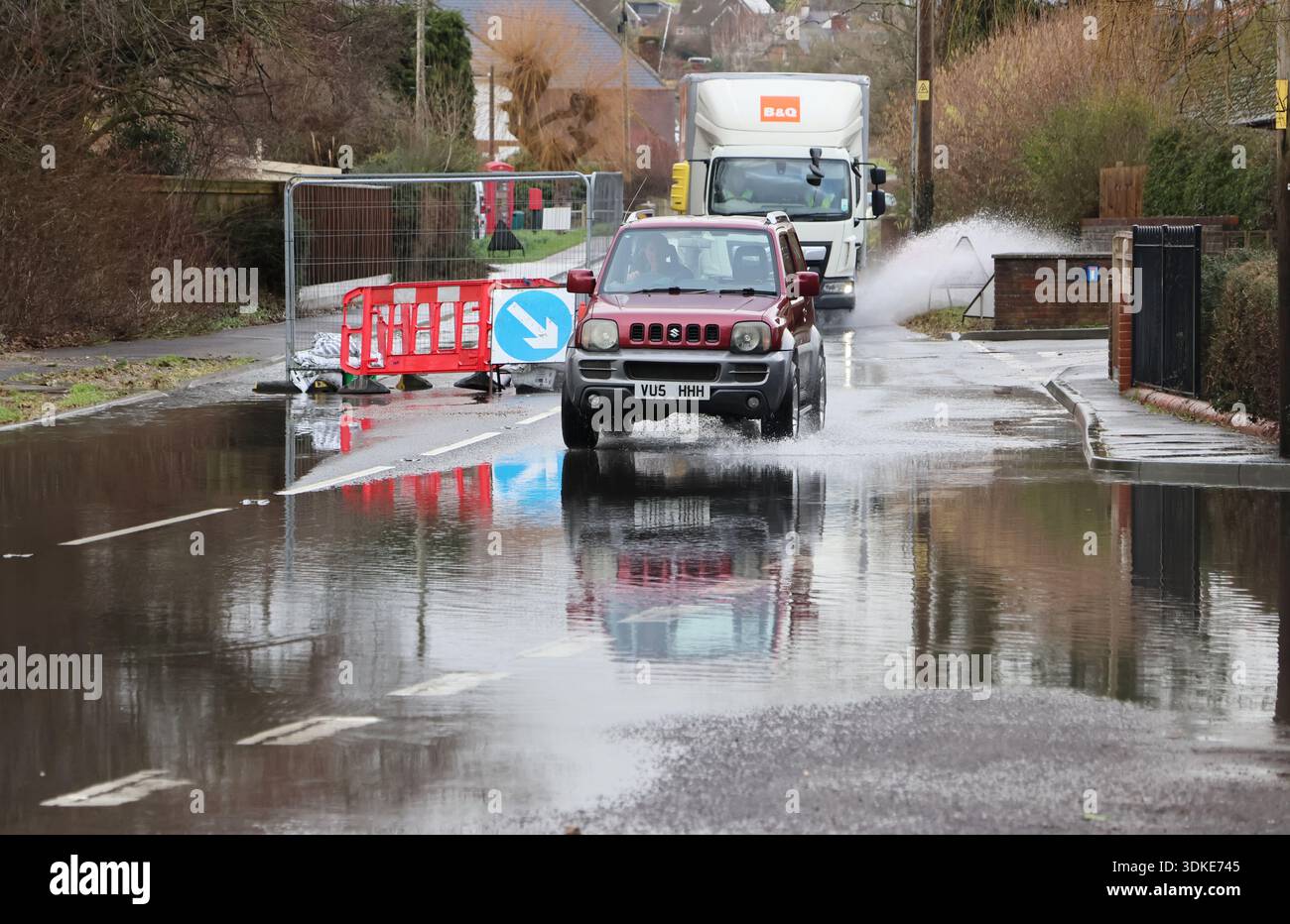 Vehicles driving through flood water on a road in Pimperne in Dorset in ...