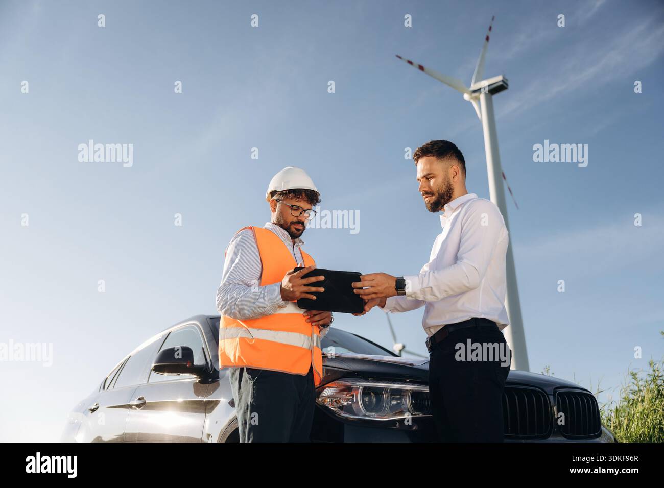 Instructions for guy in hard hat. Two men engineers are on field, with ...