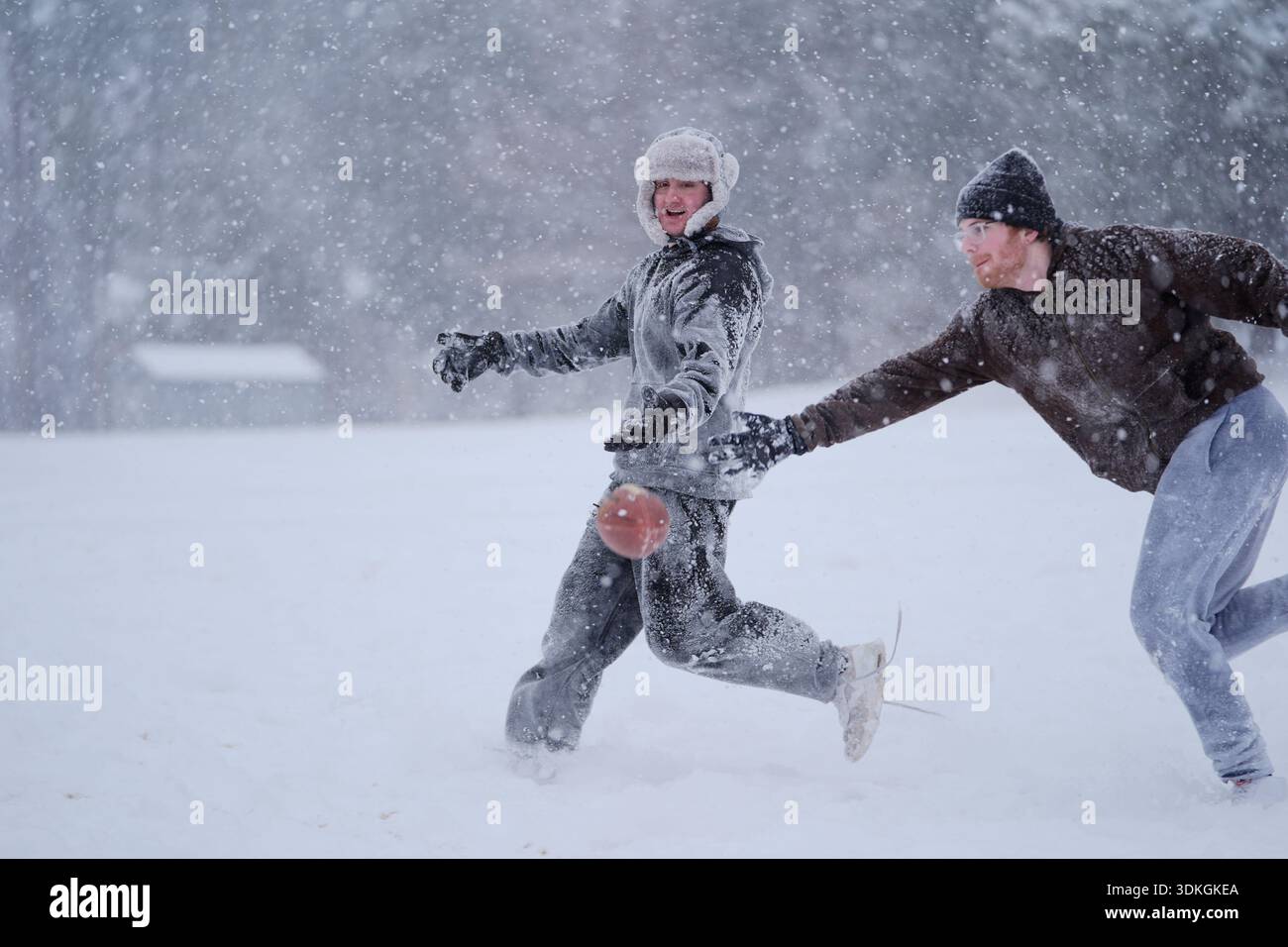 Nathan Rattey, left, and William Nurse, play football in the snow in ...