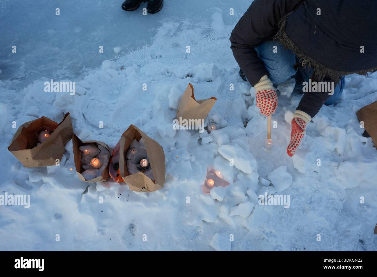 People gather and light candles during a protest spelling "ICE Out ...