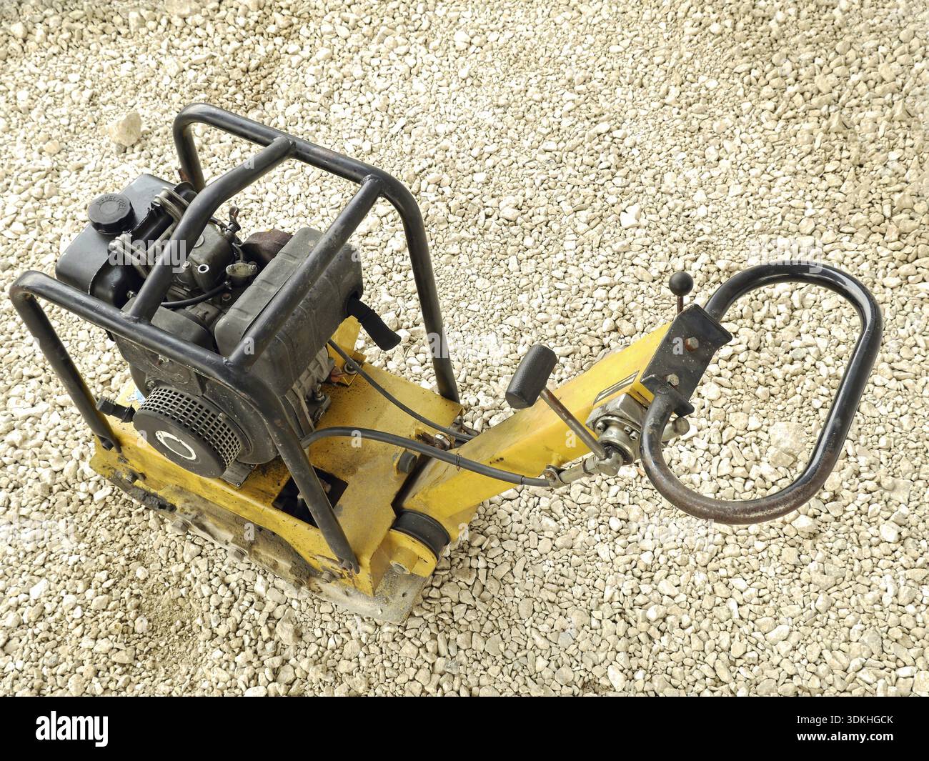 Old yellow plate compactor on aggregate bed Stock Photo - Alamy
