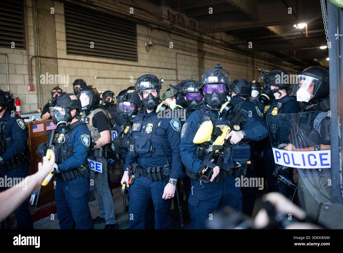 Police in riot gear and gas masks hold the line at the entrance of the ...