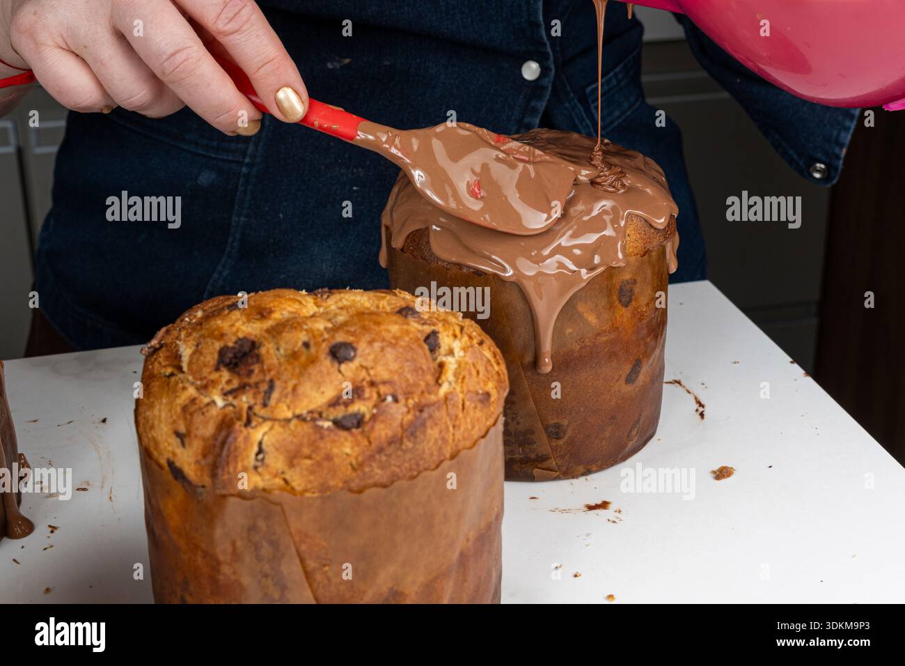 Confectioner applying chocolate frosting panettone hi-res stock ...