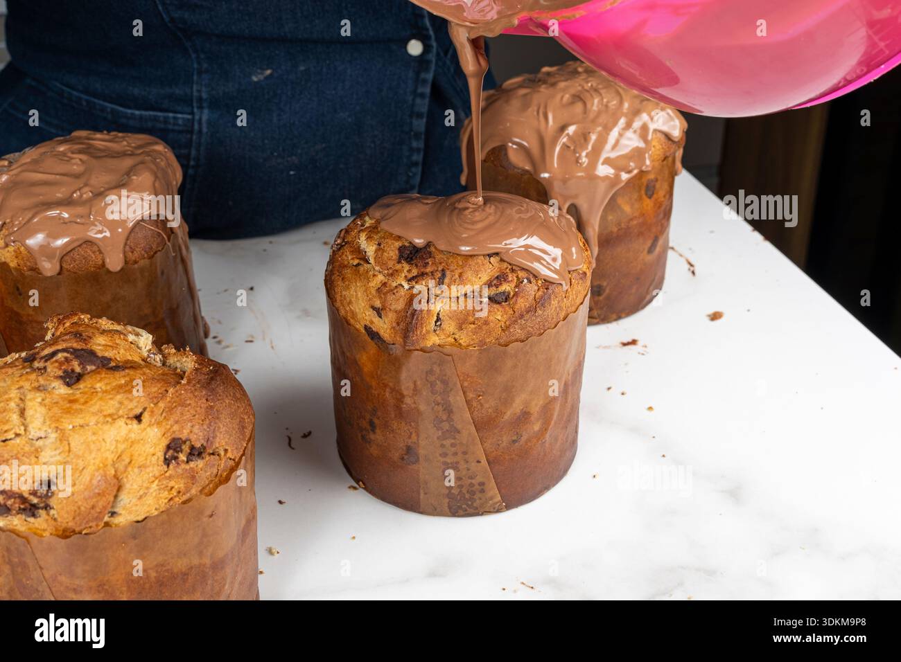 Confectioner applying chocolate frosting panettone hi-res stock ...