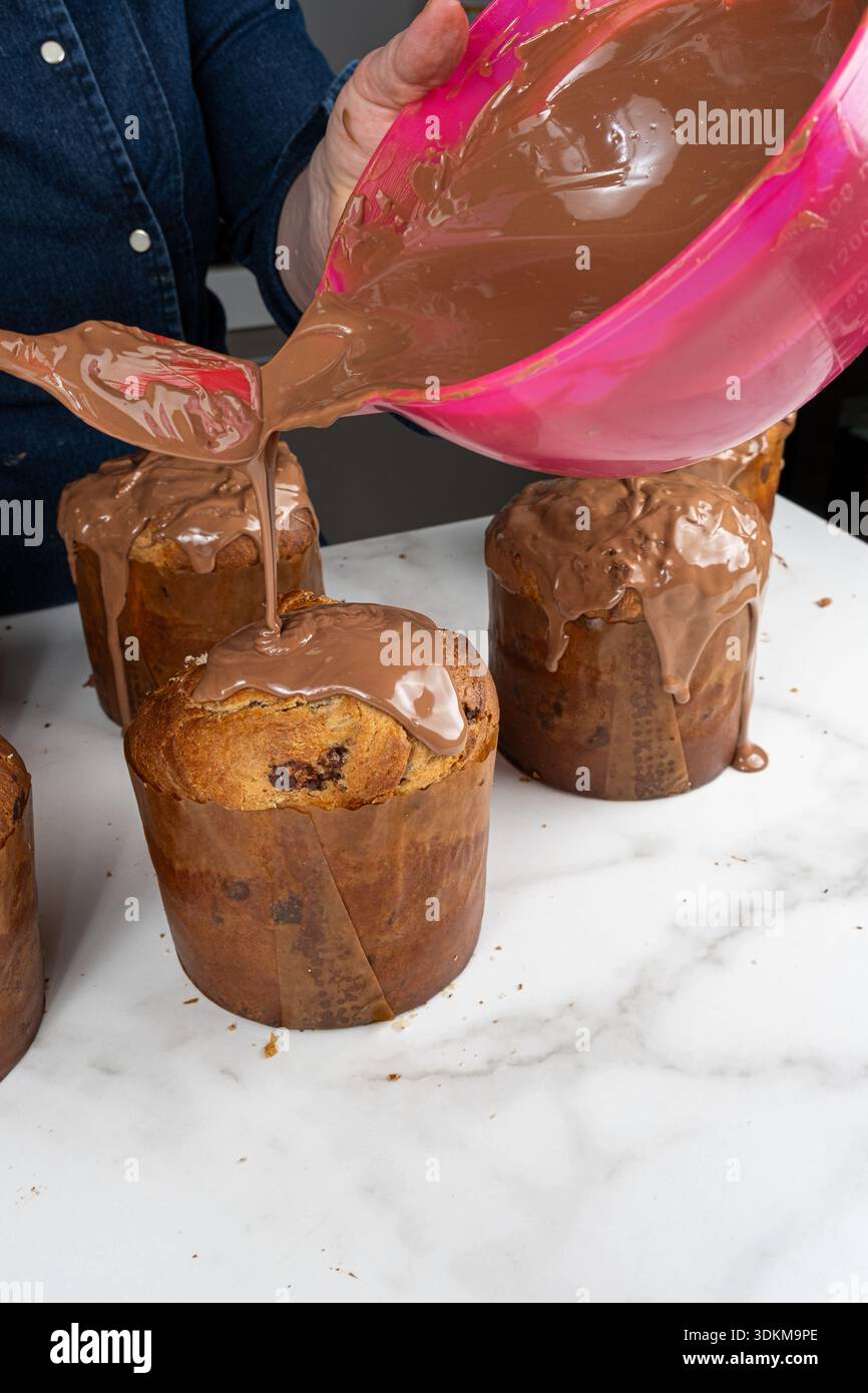 Confectioner applying chocolate frosting panettone hi-res stock ...