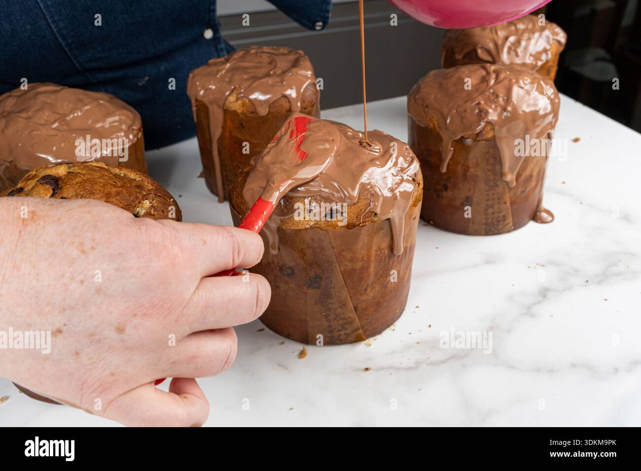 Confectioner applying chocolate frosting panettone hi-res stock ...