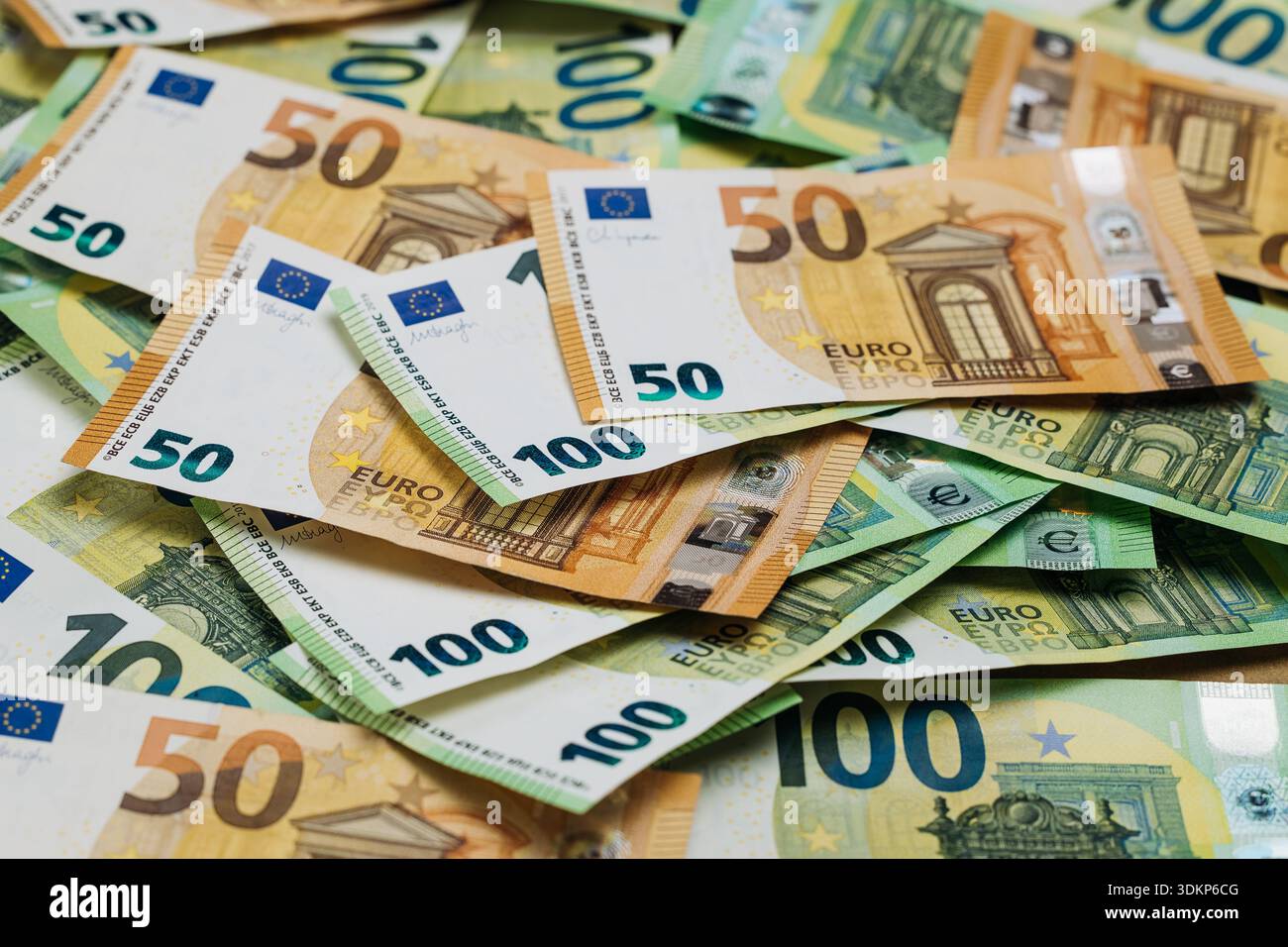 Assorted Euro banknotes including 50 and 100 denominations are spread ...