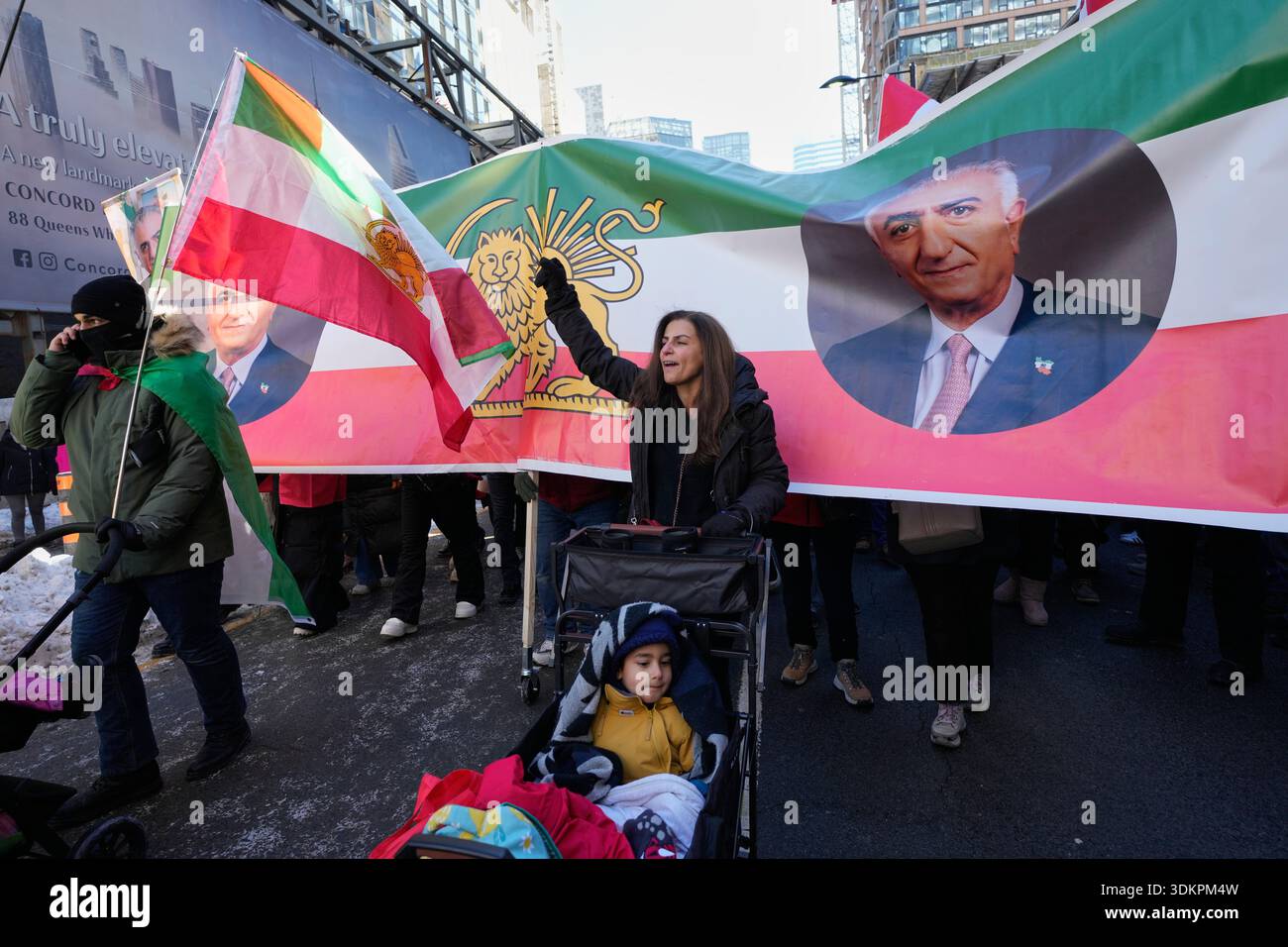 A woman chants anti-regime slogans in front of a banner with a photo of ...