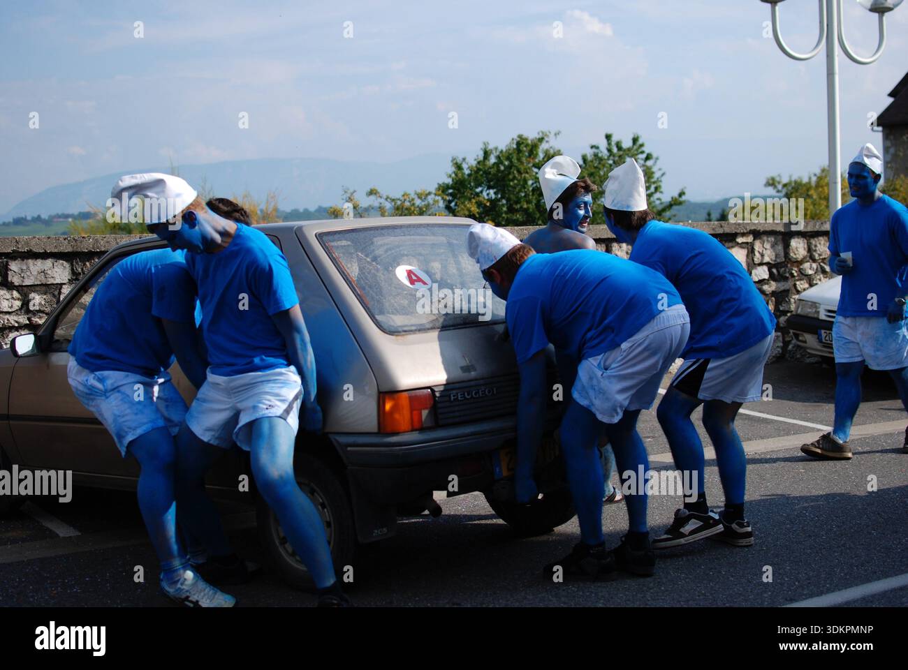 People dressed as blue Smurf characters riding a themed parade float ...