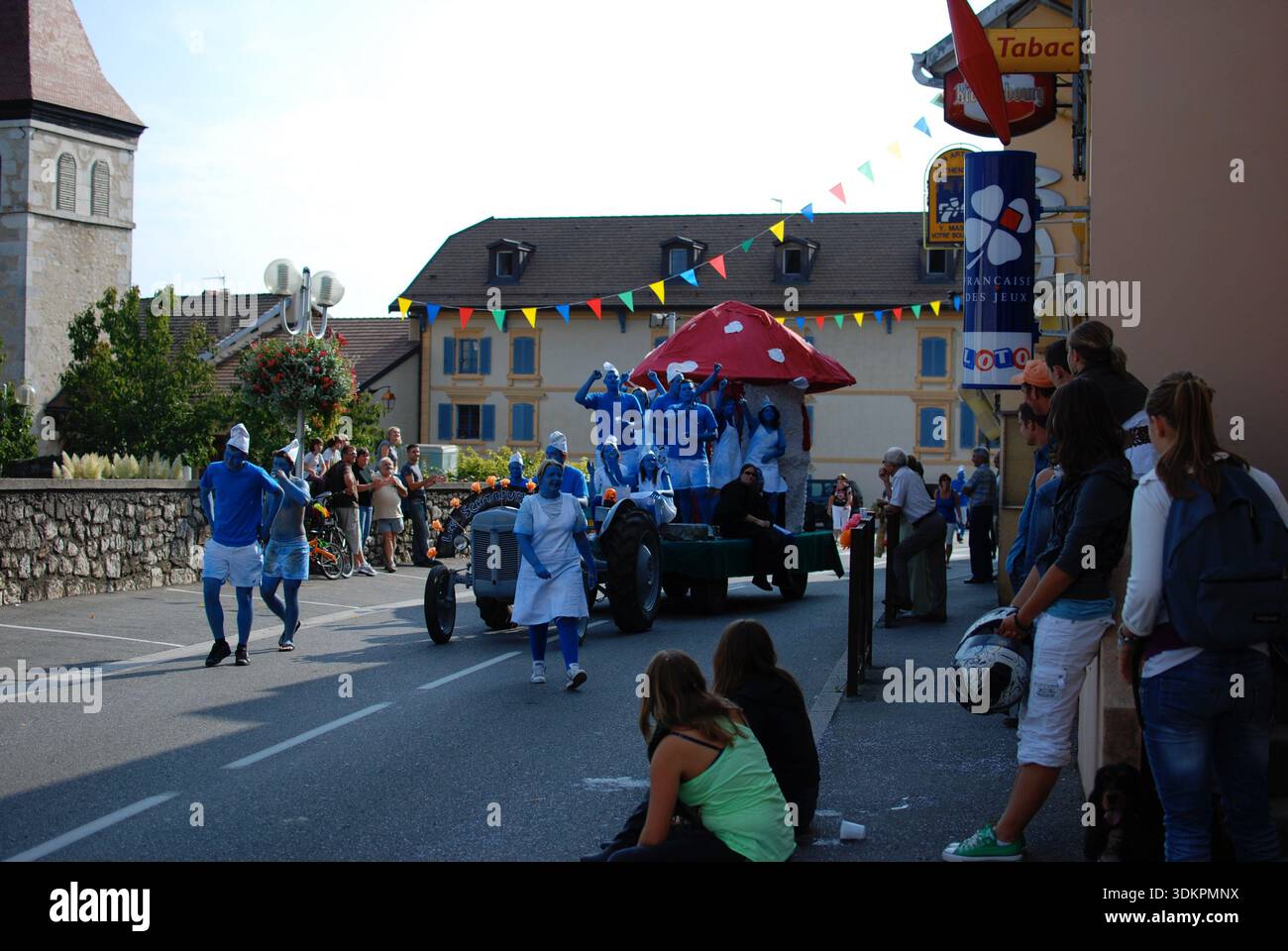 People dressed as blue Smurf characters riding a themed parade float ...