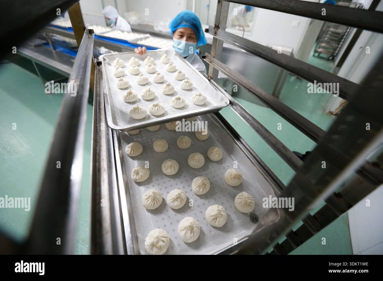 Workers make buns at a bun production enterprise in Henggou Village ...